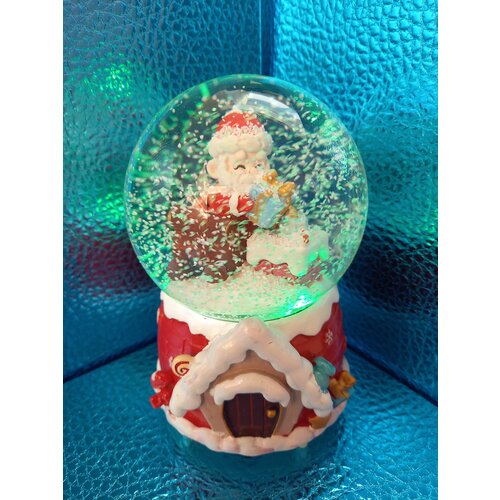 Сувенир новогодний "Волшебный шар со снегопадом" в виде Деда Мороза с подарками на крыше маленького домика.